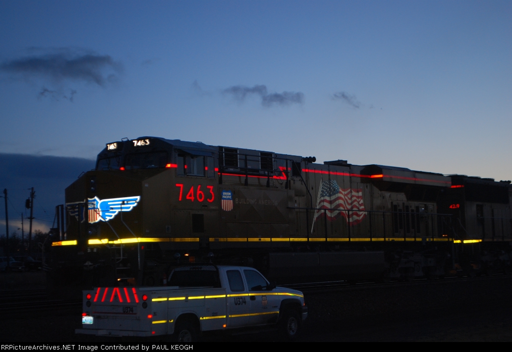 UP 7463 at dusk lights up her reflective paint as she waits for a crew west of the UP Depot.